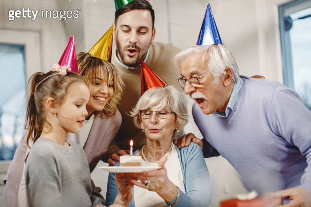 Happy multi-generation family blowing Birthday candle on a cake. 이미지 ...