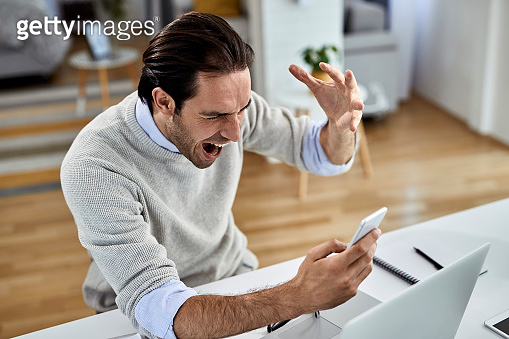 Frustrated businessman screaming while reading problematic text message ...