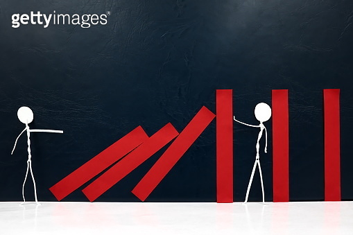 Stick man figure pushing a line of domino while another one stopping it ...