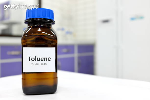 Selective focus of toluene liquid chemical compound in dark glass ...