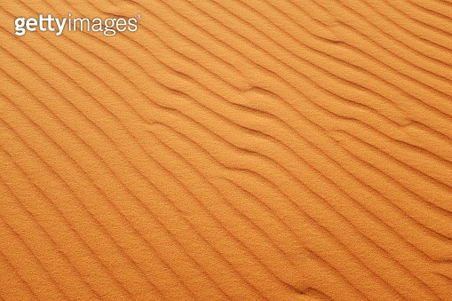 Bright saturated orange color desert sand wave patterns for a warm ...