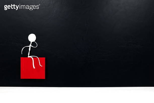 Human stick figure sitting alone in black background with copy space ...