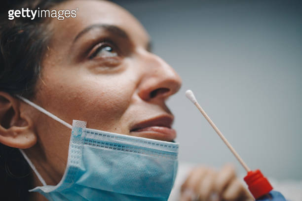 Male doctor with protective equipment taking a cotton swab test from a ...