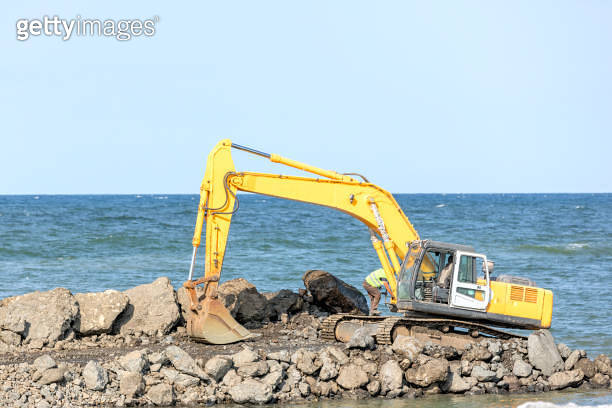 The excavator is working to build pier of harbor in the construction ...
