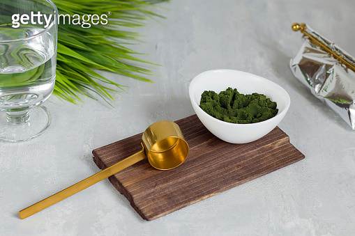 Chlorella algae powder on a light background. A green superfood detox ...