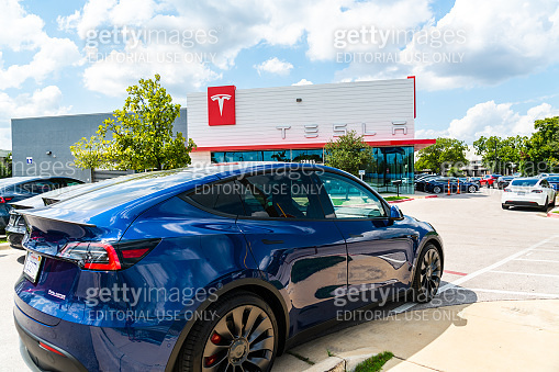 Blue Tesla Model Y in front of Tesla Building in Northwest Austin on a ...