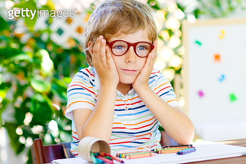 Upset school kid boy making homework during quarantine time from corona ...