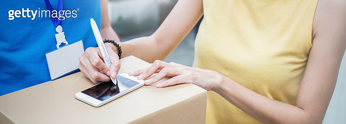 Close up woman hand appending receive sign signature after accepting a ...