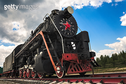 vintage steam train hurtling at speed along the rails close-up, retro ...