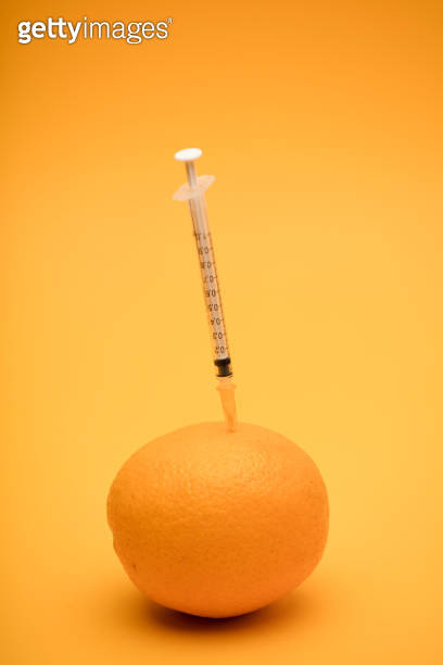 orange with syringe, genetic engineering lab, transgenic food concept ...