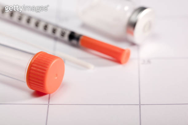 PCR vial with orange cap, syringe with orange cannula and transparent ...