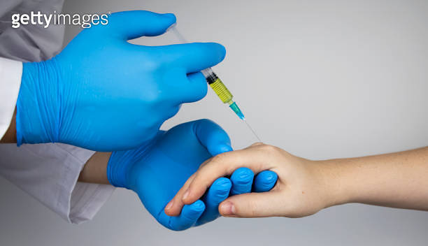 An orthopedic surgeon gives an injection in the finger joint. Treatment ...