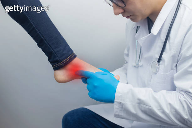 An orthopedic surgeon examines a woman's leg. Foot pain, tendon sprains ...