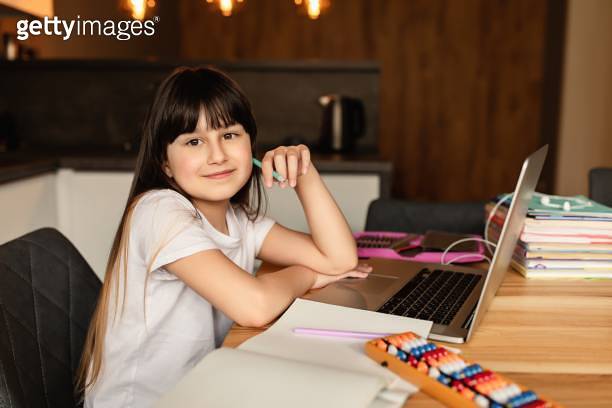 Online learning at home. Girl looks at the camera. Happy schoolgirl ...