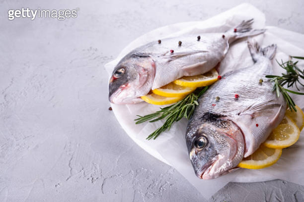 Delicious fresh fish on gray background. Fish with aromatic herbs ...