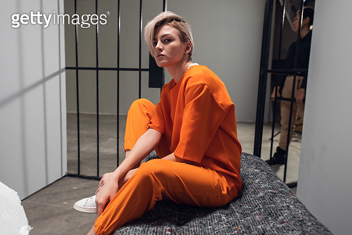 A young pretty blonde prisoner in a general regime prison is sitting in ...