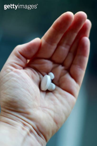 Hand holding a mixture of white pills 이미지 (1280129138) - 게티이미지뱅크