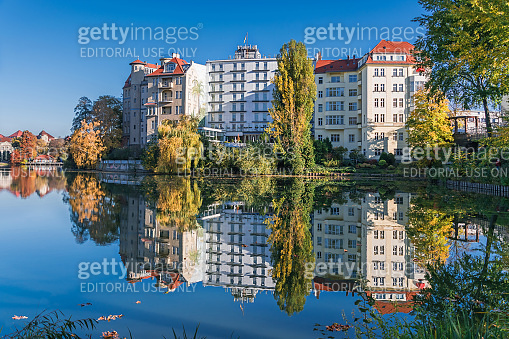 Park at the shore of Lake Lietzen with buildings reflecting in the ...