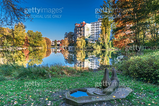 Park at the shore of Lake Lietzen with buildings reflecting in the ...