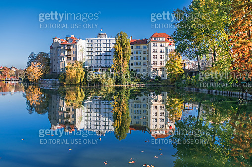 Park at the shore of Lake Lietzen with buildings reflecting in the ...