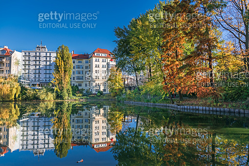 Park at the shore of Lake Lietzen with buildings reflecting in the ...