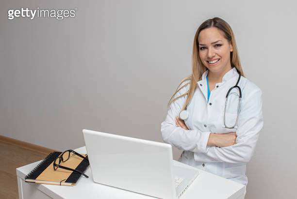 Confident doctor sitting arms crossed. Confident young woman doctor ...