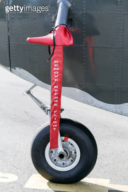 Remove before flight tag sign attached to an aircraft. Warning label ...