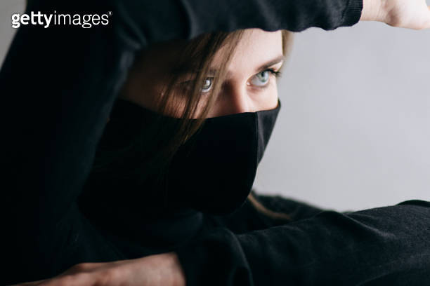 portrait of young beautiful woman in a black stylish mask in a combat ...