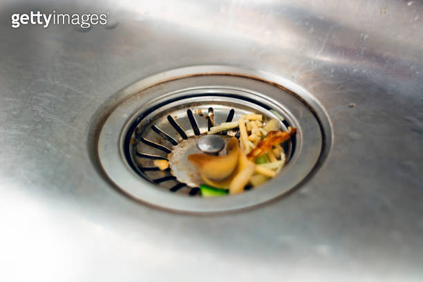 the leftovers of food left inside the kitchen sink are about to clog ...