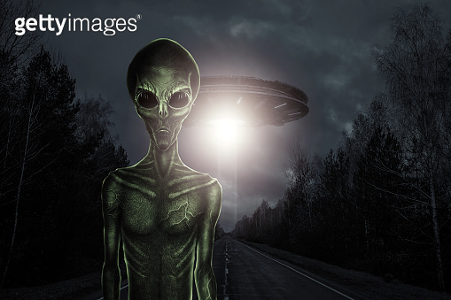 Green alien with black large glass eyes on the background of a flying ...