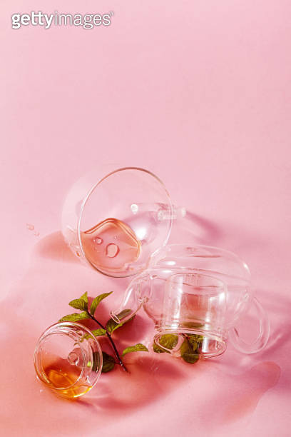 thrown glass teapot and spilled tea on a pink background. abstract 이미지 ...