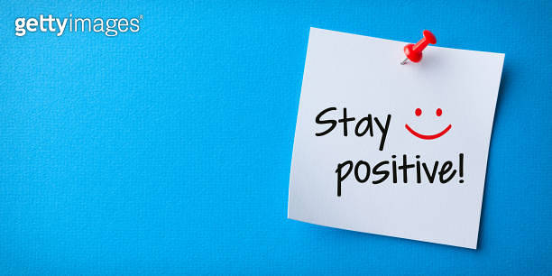 White Sticky Note With Stay Positive And Red Push Pin On Blue ...