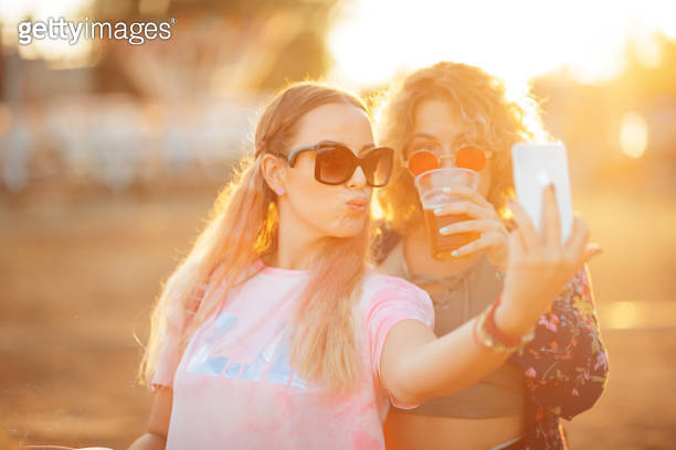 Young Woman With Friend Puckering Lips And Taking A Selfie 이미지
