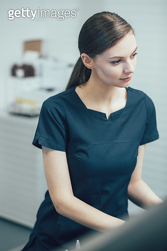 Calm lab worker in dark uniform sitting alone 이미지 (1278650795) - 게티이미지뱅크