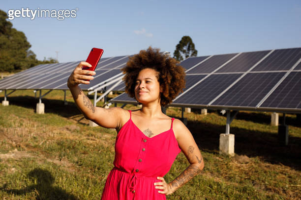 Woman talking a selfie with solar panels on background 이미지 (1282949463 ...