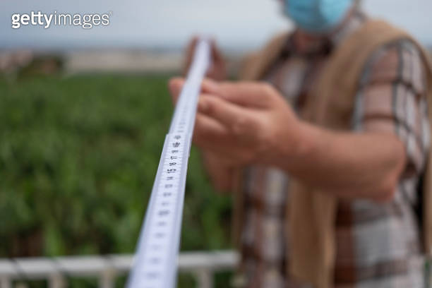 Defocused senior man outdoor on the terrace holding a meter for social ...