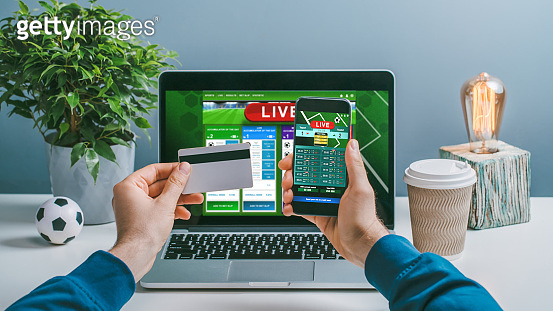 Front view of a man making bets online at bookmaker's website and ...