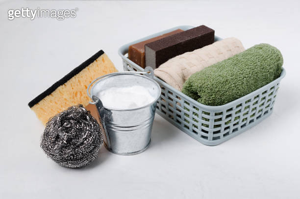 Closeup of bucket full of baking soda, metal scrubber, basket with ...