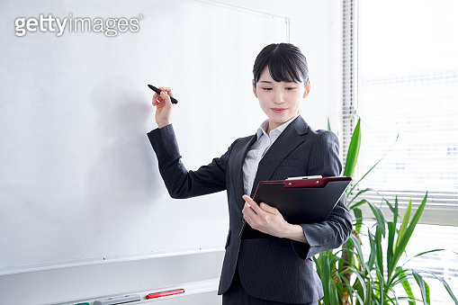 Japanese woman writing on a whiteboard 이미지 (1275794676) - 게티이미지뱅크