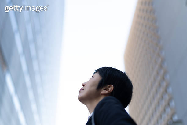 Asian woman looking up at office buildings 이미지 (1202972890) - 게티이미지뱅크