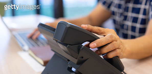 close up senior woman hand touching on handset telephone to calling to ...