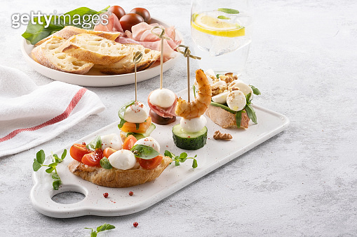 Traditional spanish tapas appetizer. Pinchos with mozzarella, cucumbers ...