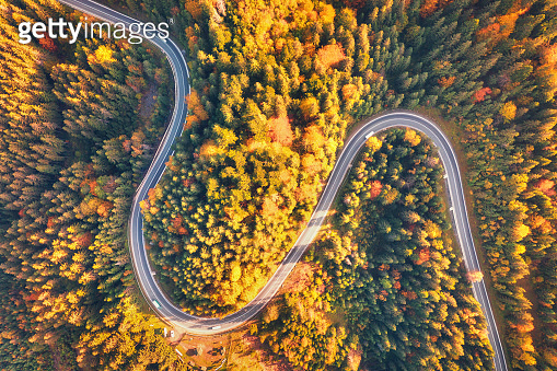 Aerial view of mountain road in beautiful forest at sunset in autumn ...
