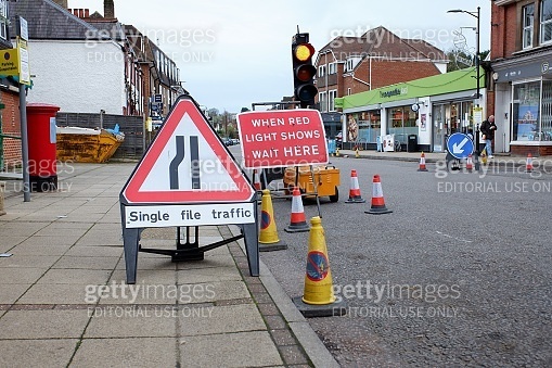 Single file traffic sign beside temporary traffic lights 이미지 ...
