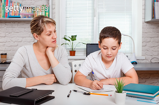 A schoolboy boy studies at home and does school homework online 이미지 ...
