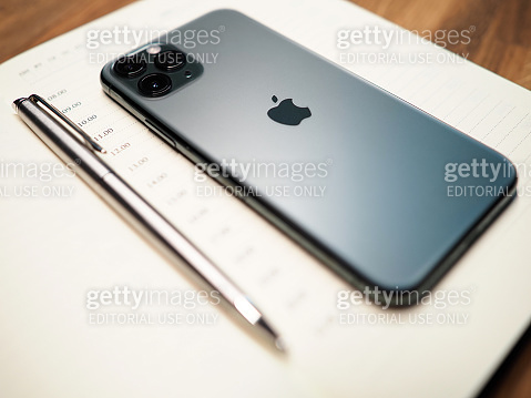 iPhone pro device lying at opened notebook 이미지 (1200778580) - 게티이미지뱅크