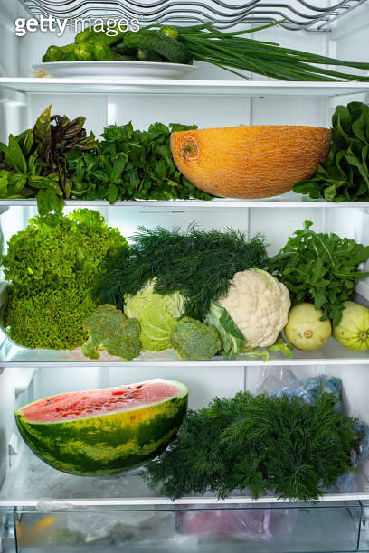 The contents of the refrigerator with dill and parsley, basil, spinach ...