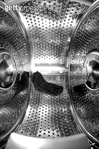 A look inside the perforated steel drum of the empty washing machine ...