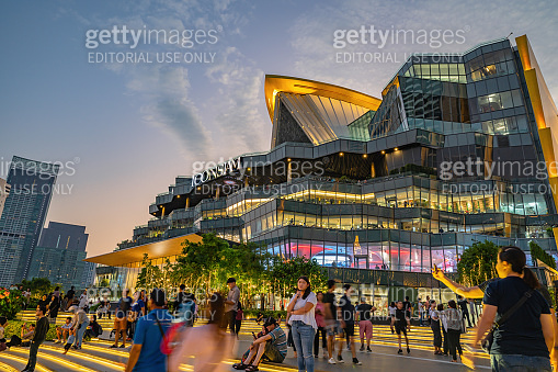 Unacquainted people walking on the park with beautiful sunset and sky ...