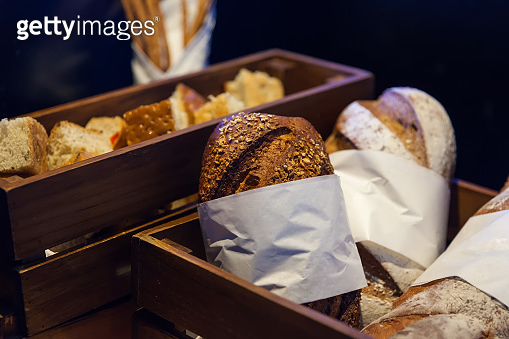 Organic whole wheat and grain bread, French baguett wrapped in wax ...